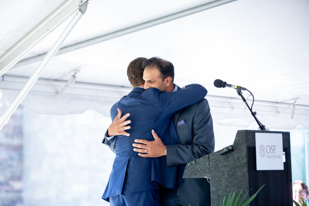 Ajay Pathak and Mike Moeller embrace