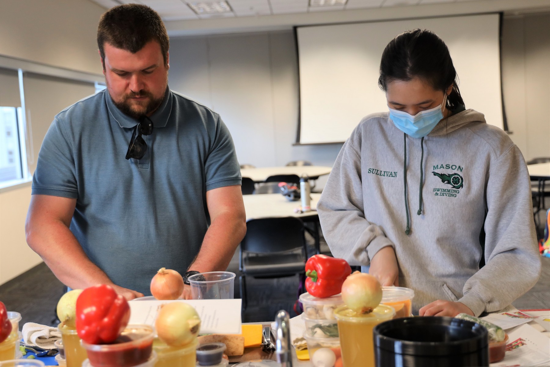 Nick Fowler and a student work on a recipe