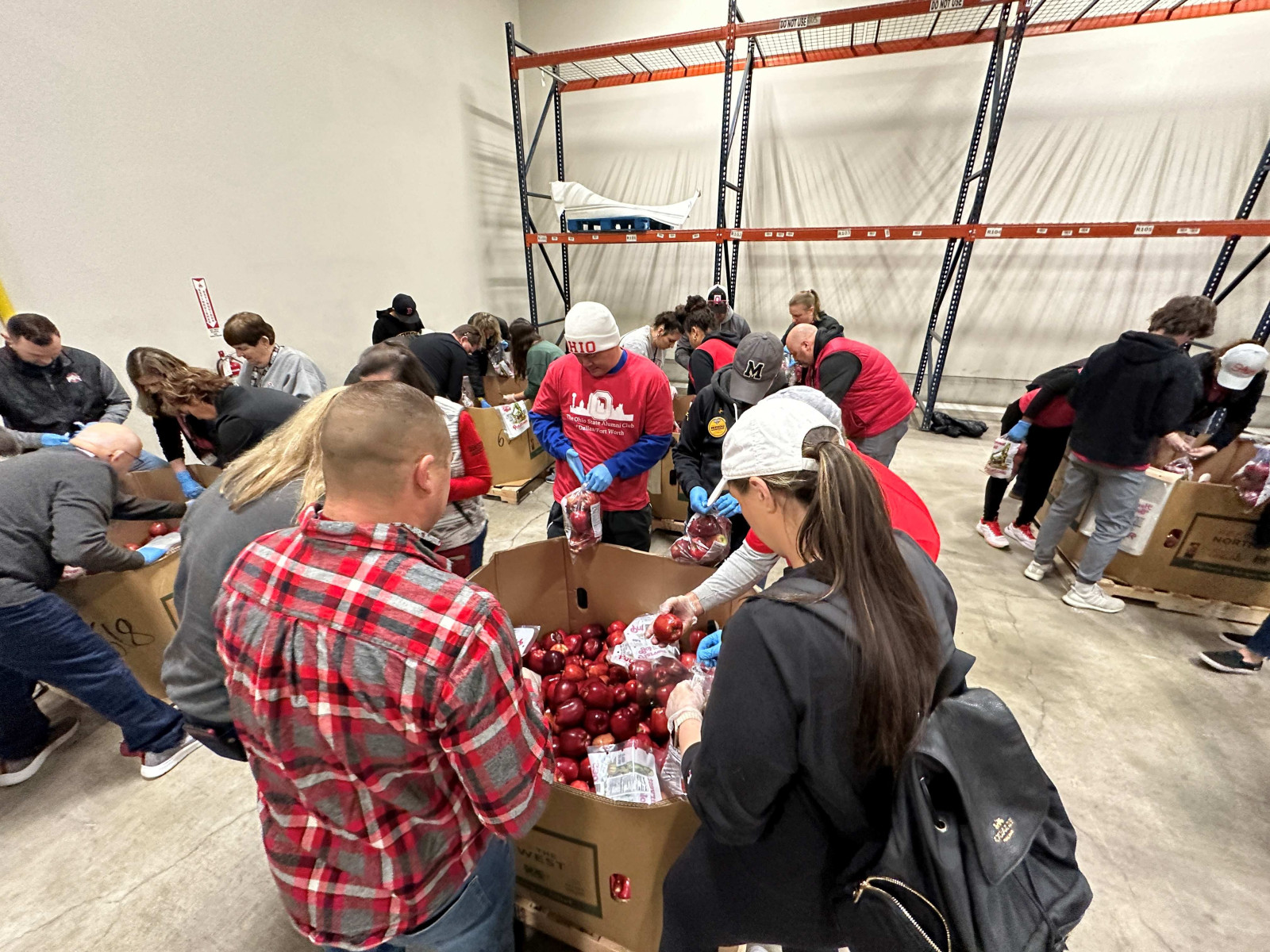 Ohio State and Missouri supporters fill bags of apples at a Fort Worth ...