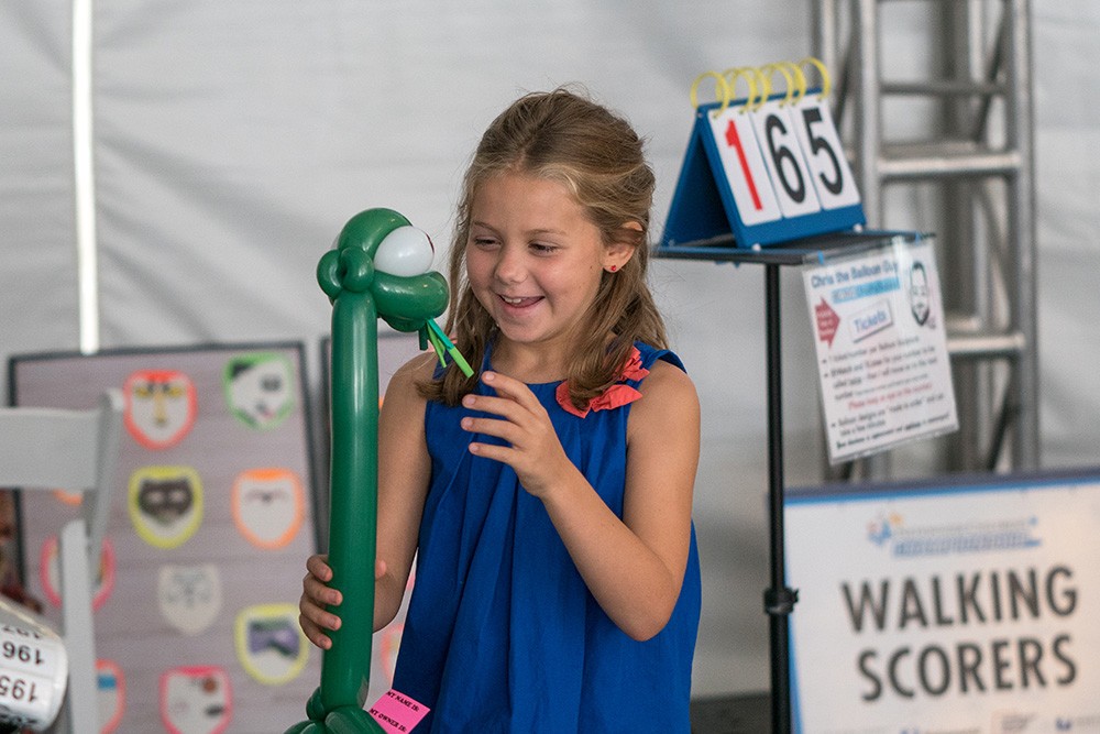 Patient Champion Emery enjoys her balloon animal.