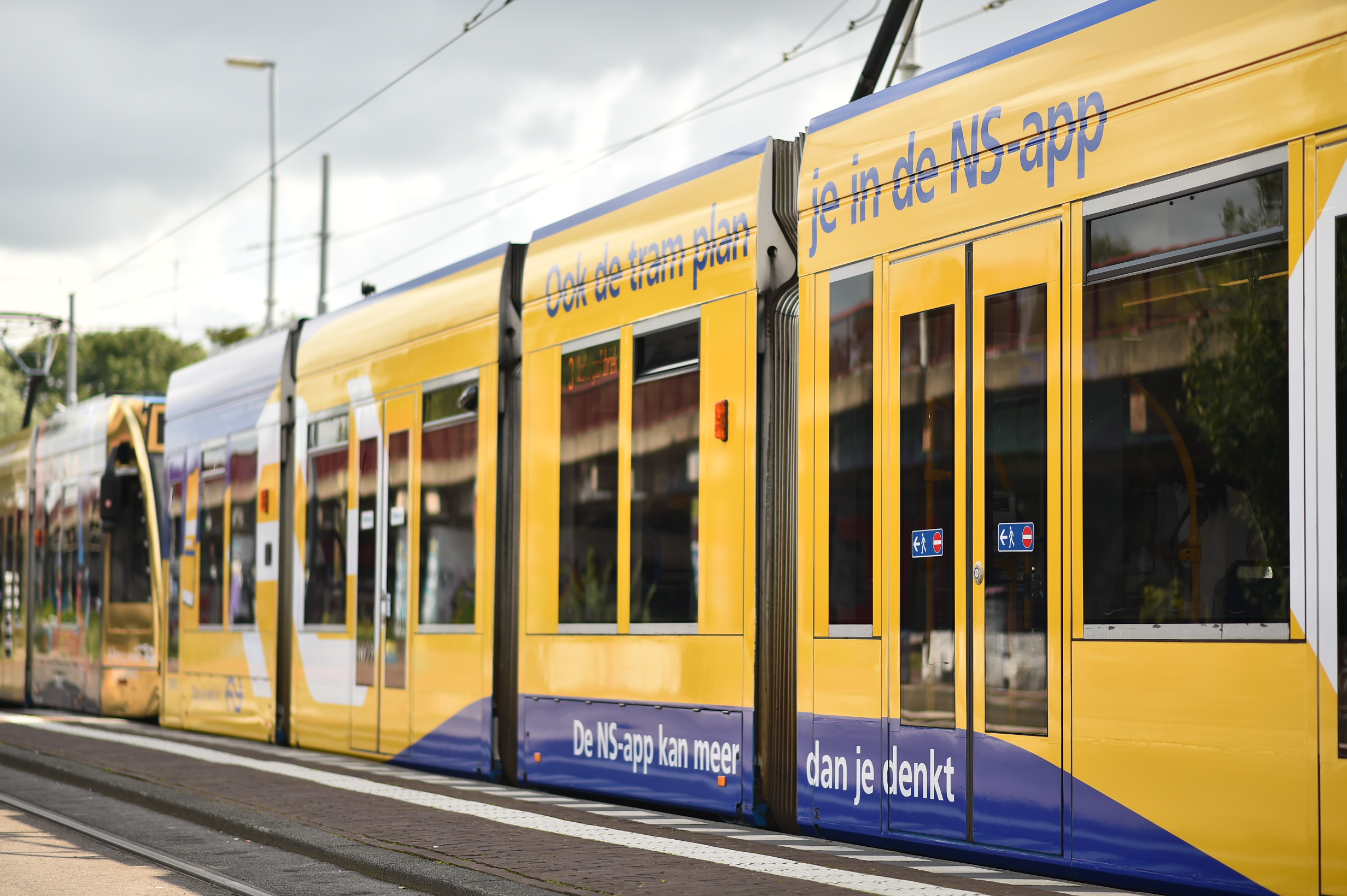 NS-trams en -bussen rijden door Den Haag en Amsterdam