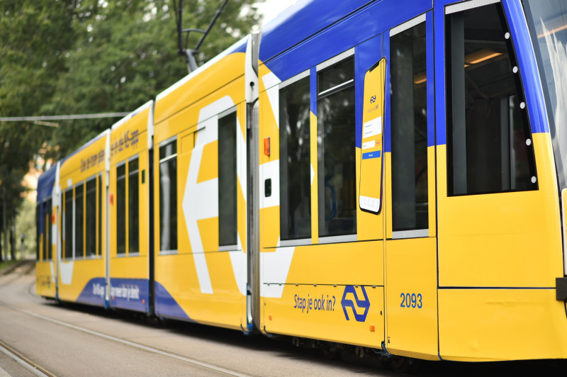 NS-trams en -bussen rijden door Den Haag en Amsterdam